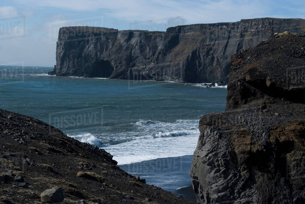 Dyrholaey cliff promontory and rock formations with black sand beach ...