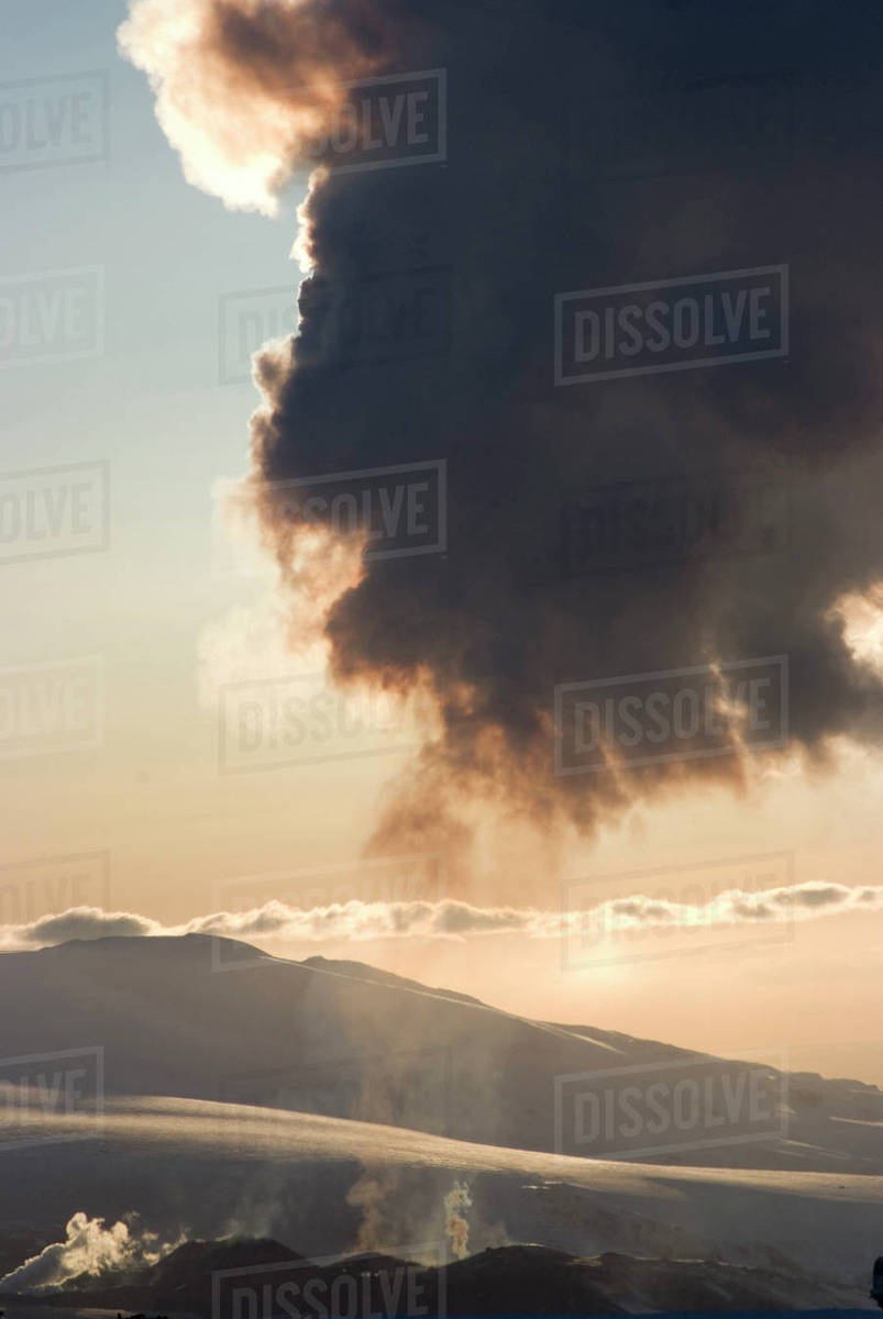 Plume of ash from Eyjafjallajokull volcano silhoeutted against sunset ...