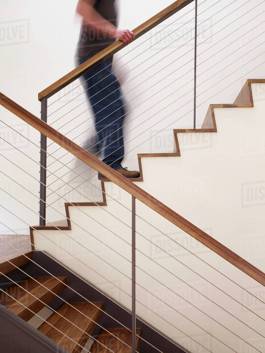 Man walking up stairs in apartment - Royalty-free Stock Photo | Dissolve