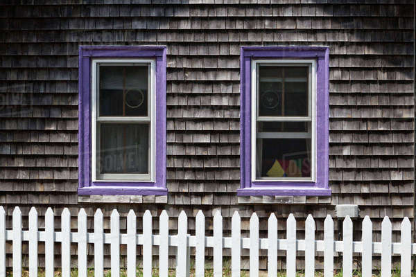 Shingles of a Carpenter Gothic cottage with white picket fence and ...