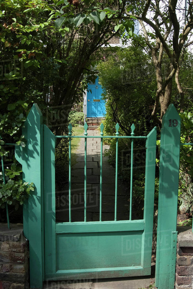Green gate leading to a blue door - Royalty-free Stock Photo | Dissolve