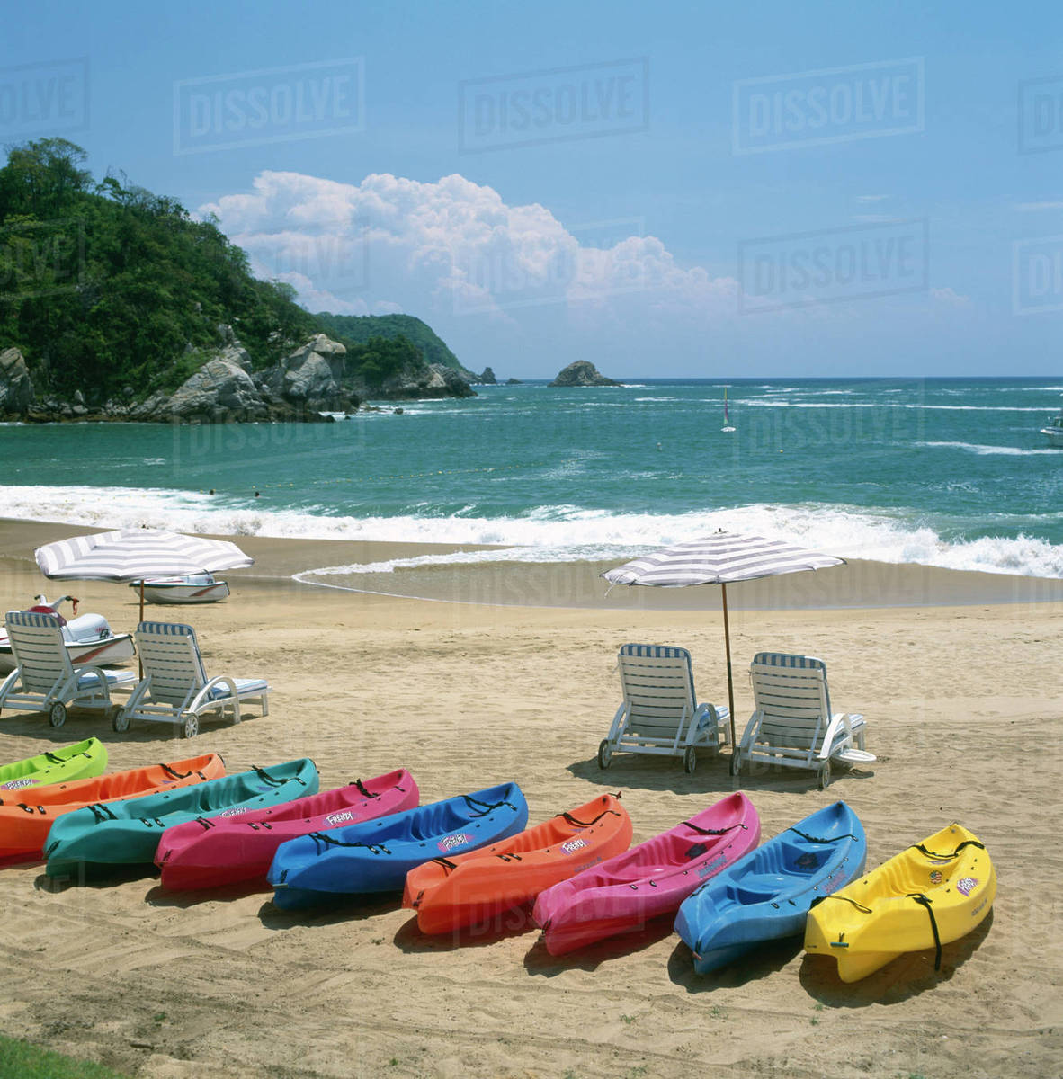 A row of colourful canoes on a beach - Royalty-free Stock Photo | Dissolve