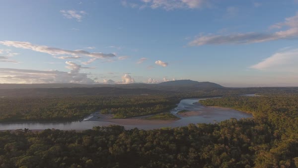 Aerial shot panning over the Rio Napo at sunset, with the Sumaco ...