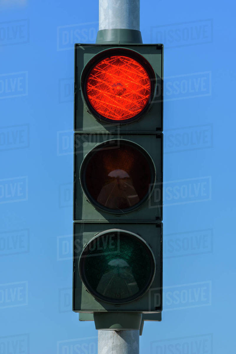 Red Traffic Light Against Blue Sky, Denmark - Stock Photo - Dissolve