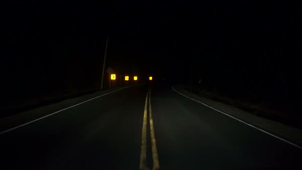 Driving down a twisting and turning dark rural highway at night ...
