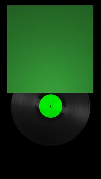 A vinyl record spinning half out of an album cover. Green screen to key ...