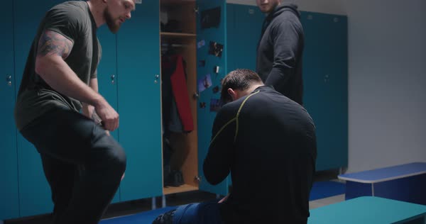 Medium shot of two men bullying their peer in locker room - 4K Royalty ...