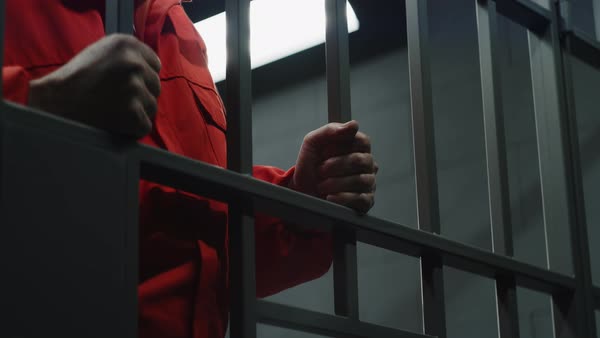 Close up of criminal holding metal bars, standing in prison cell - 4K ...