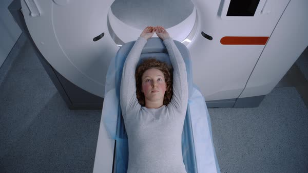 Patient lies on CT, PET, or MRI scan bed, moves inside machine - Stock ...