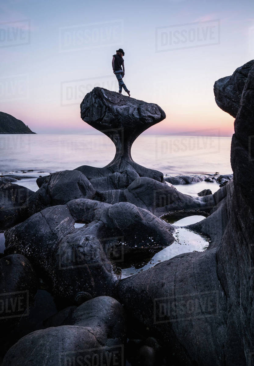 Woman standing on rock against sky during sunset - Royalty-free Stock ...