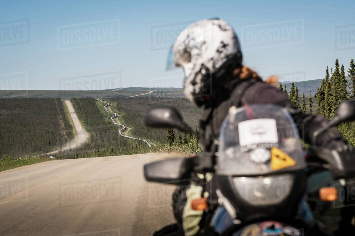Woman looking back while sitting on motorbike - Royalty-free Stock ...
