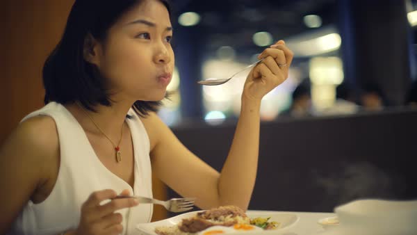 Young Asian Lady eating Thai food in cafe - Stock Video Footage - Dissolve