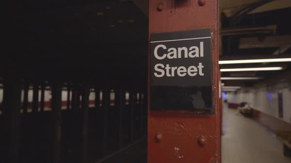 Medium shot of Canal Street sign on pole in subway station, New York ...