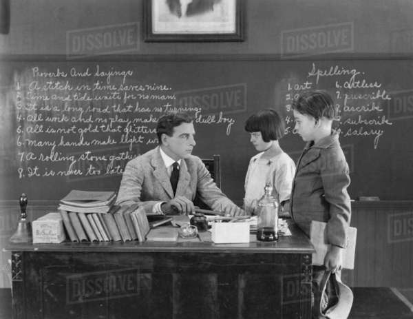 Teacher spanking a girl in a classroom - Stock Photo - Dissolve