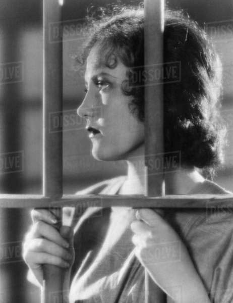 Closeup of woman behind bars - Stock Photo - Dissolve