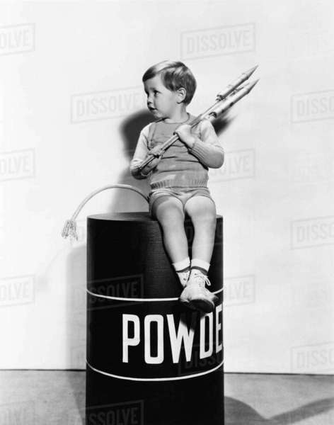 Little boy sitting on powder keg - Royalty-free Stock Photo | Dissolve