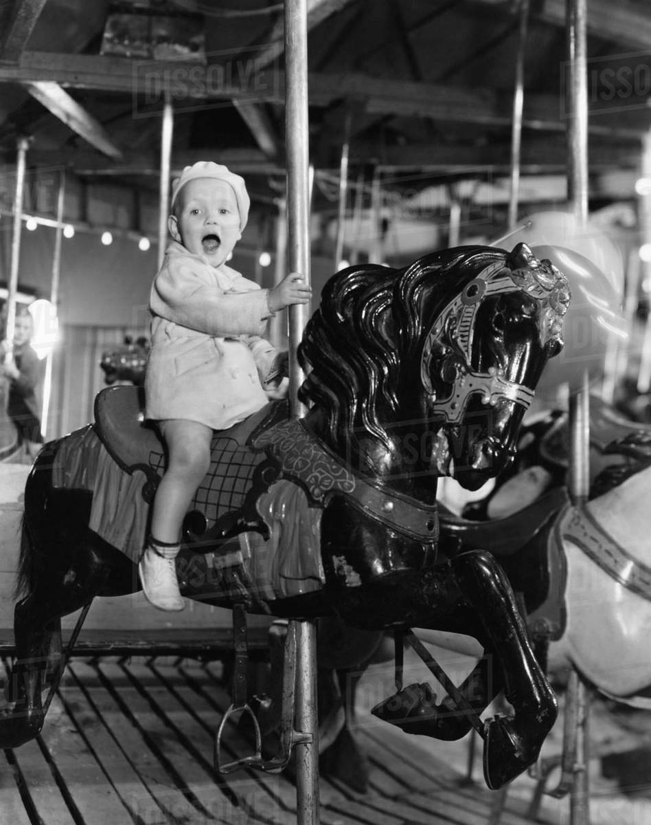 Toddler on carousel - Stock Photo - Dissolve
