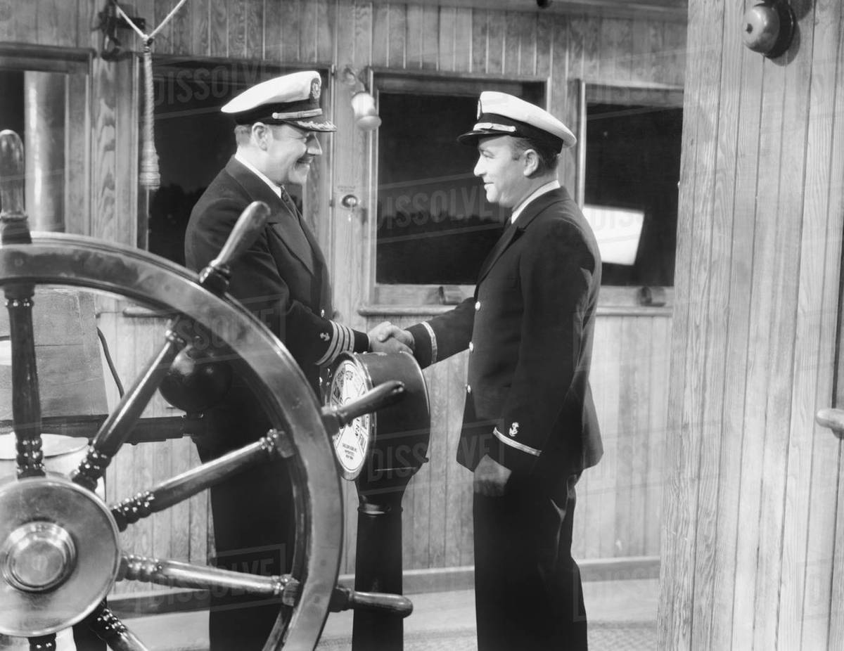 Two captains shaking hands on a boat - Stock Photo - Dissolve