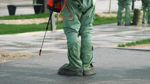 Medical workers in bio viral hazard protective suits spray of chemicals ...