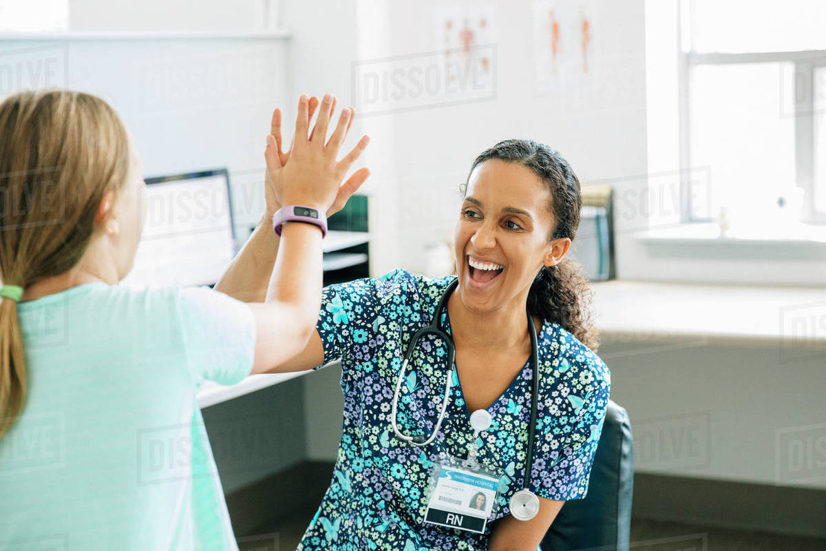 Nurse high-fiving girl - Royalty-free Stock Photo | Dissolve