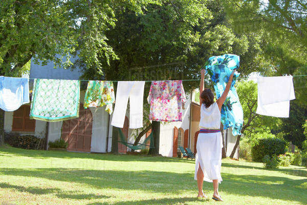 Caucasian woman hanging laundry on clothes line - Royalty-free Stock ...