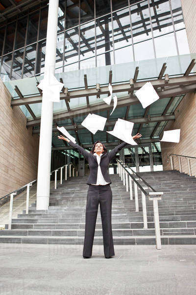 Indian businesswoman throwing papers into the air - Stock Photo - Dissolve