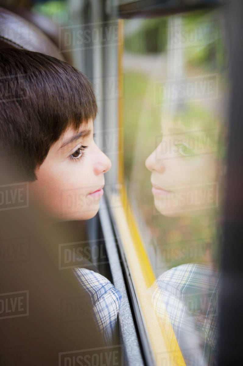 Caucasian boy riding school bus - Royalty-free Stock Photo | Dissolve