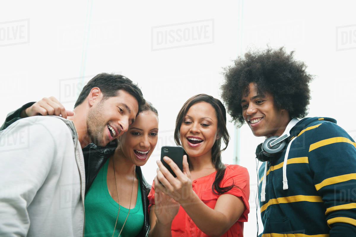 Friends looking at cell phone - Royalty-free Stock Photo | Dissolve