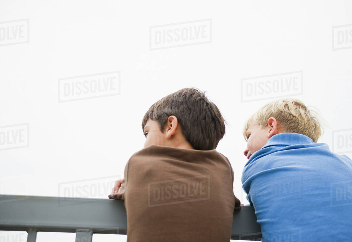 Boys standing looking over railing - Royalty-free Stock Photo | Dissolve