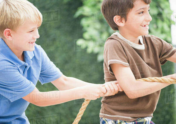 Boys pulling rope together - Stock Photo - Dissolve