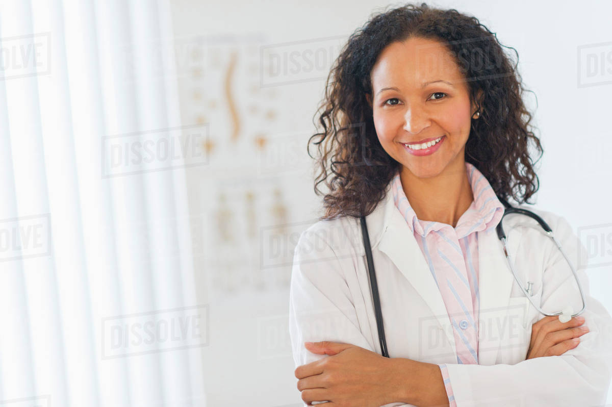 Hispanic doctor standing in hospital - Royalty-free Stock Photo | Dissolve