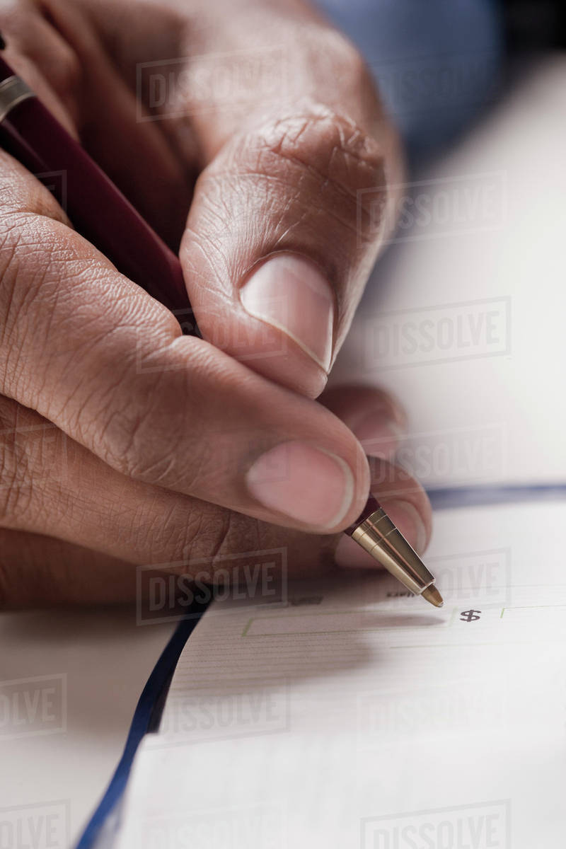 Mixed race man writing a check - Royalty-free Stock Photo | Dissolve