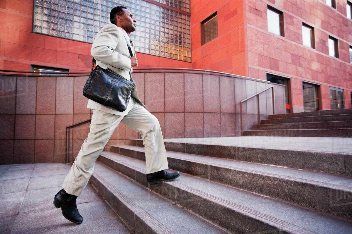 African American businessman running up steps - Royalty-free Stock ...