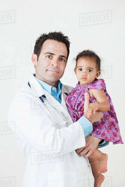 Doctor holding baby girl - Stock Photo - Dissolve