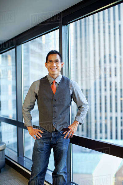 Smiling mixed race businessman standing in office - Royalty-free Stock ...