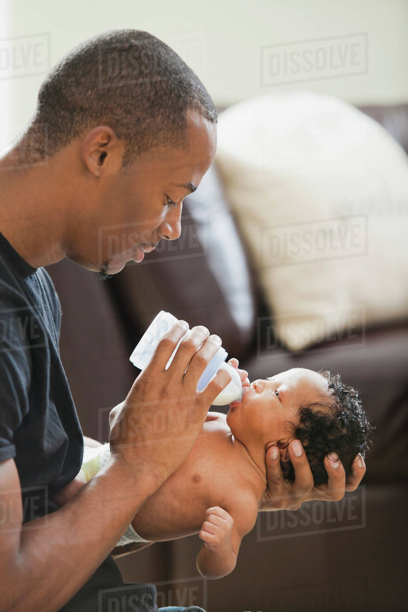 Father feeding bottle to newborn baby - Royalty-free Stock Photo | Dissolve