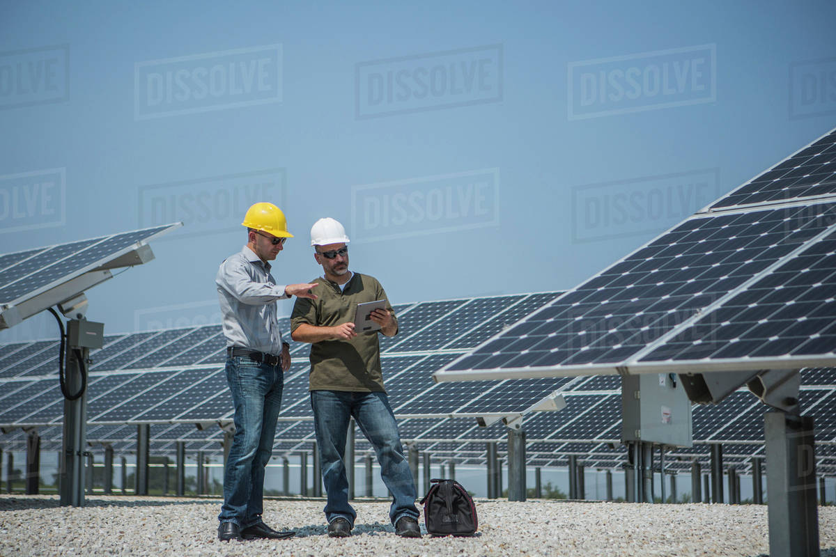 Caucasian technicians talking near solar panels - Royalty-free Stock ...