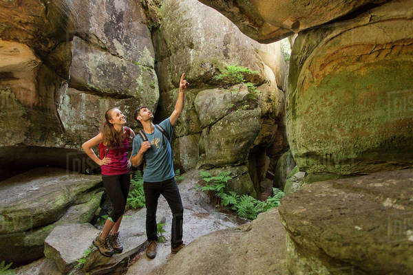 Caucasian couple exploring cave - Stock Photo - Dissolve