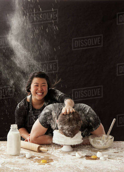 Woman shoving face of boyfriend in cake - Royalty-free Stock Photo ...