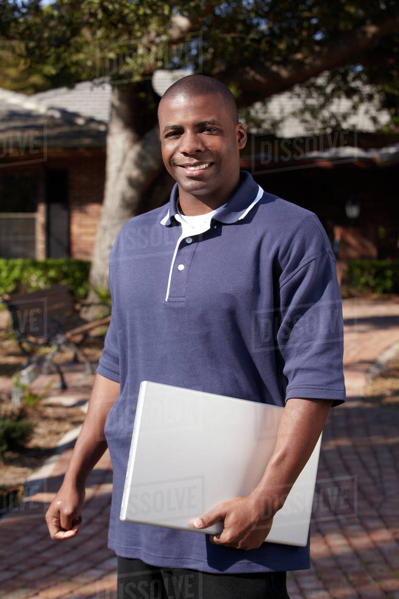 Black man carrying laptop - Royalty-free Stock Photo | Dissolve