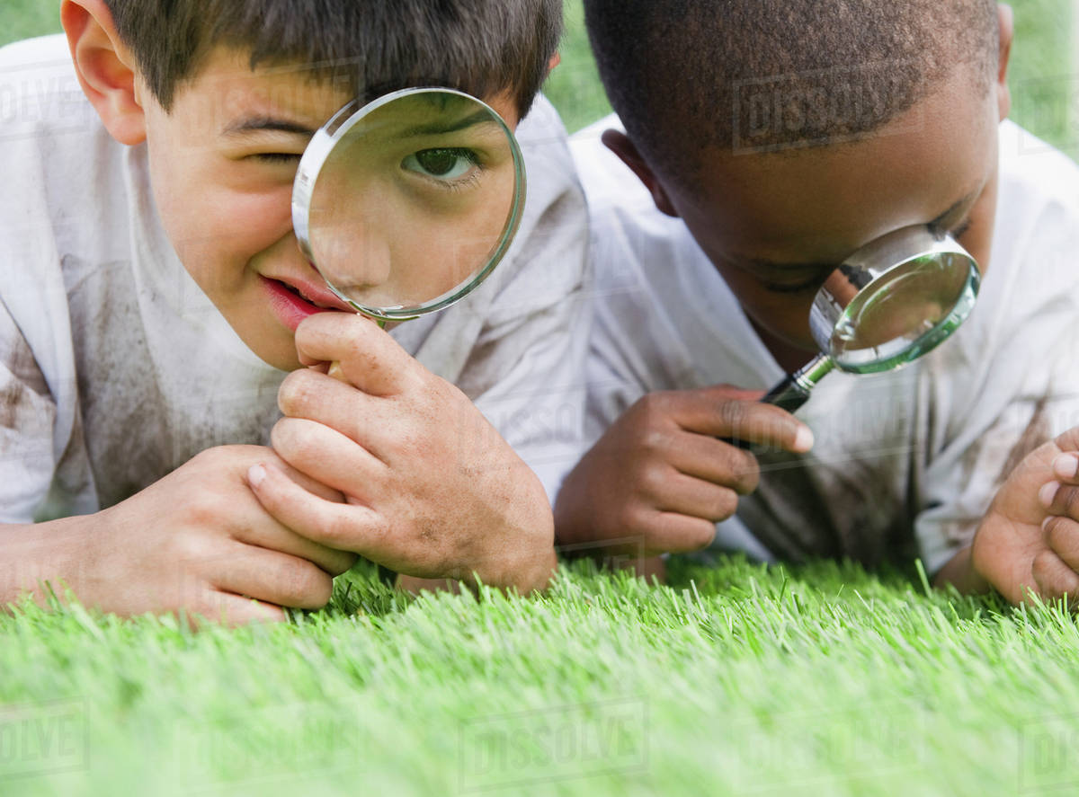 Boys looking at grass through magnifying glasses - Royalty-free Stock ...
