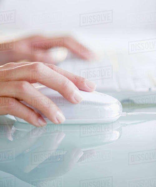 Hands operating computer mouse and keyboard - Stock Photo - Dissolve