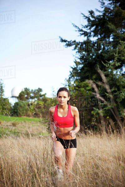 Jogger running through field - Stock Photo - Dissolve