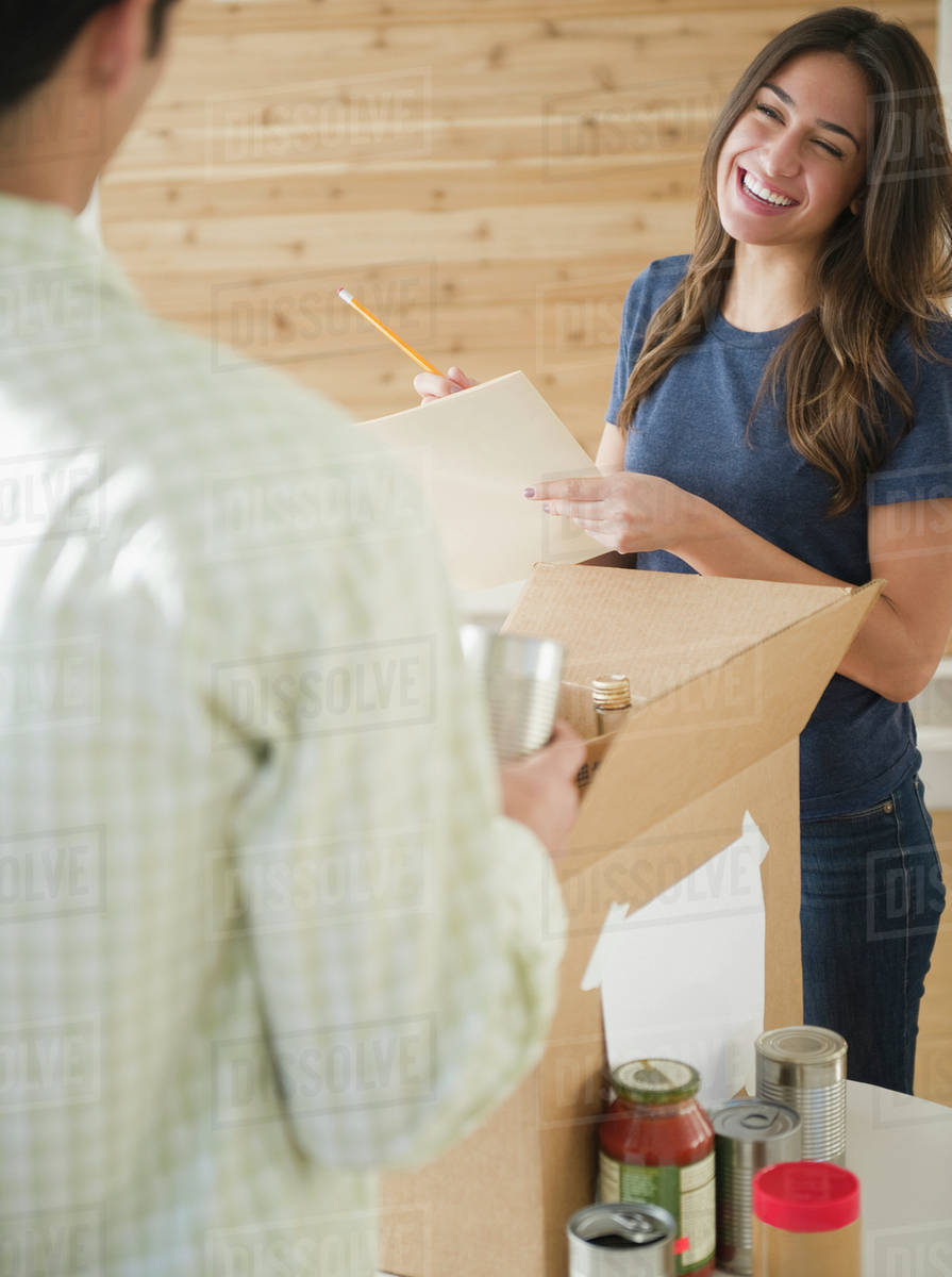 Couple packing boxes together - Stock Photo - Dissolve