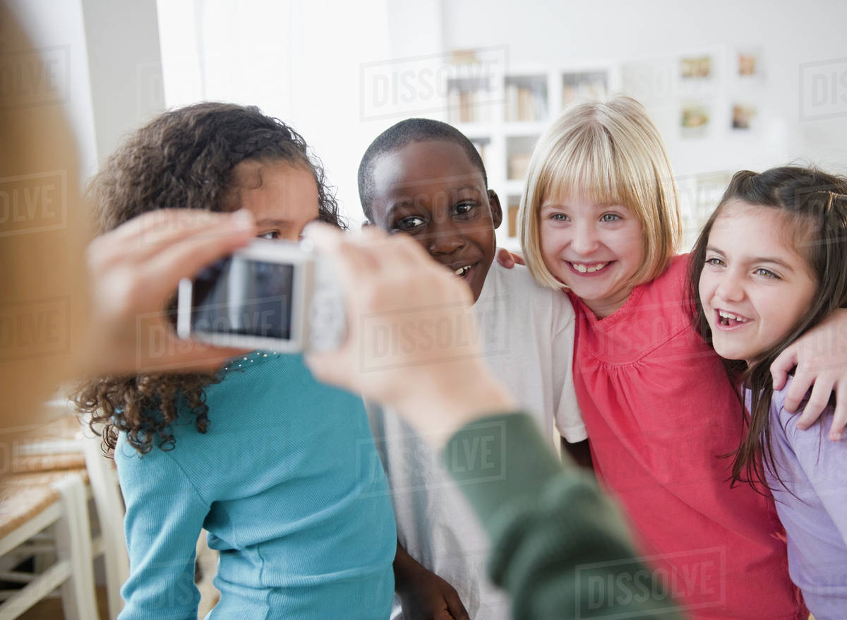 Girl taking photograph of friends with digital camera - Stock Photo ...