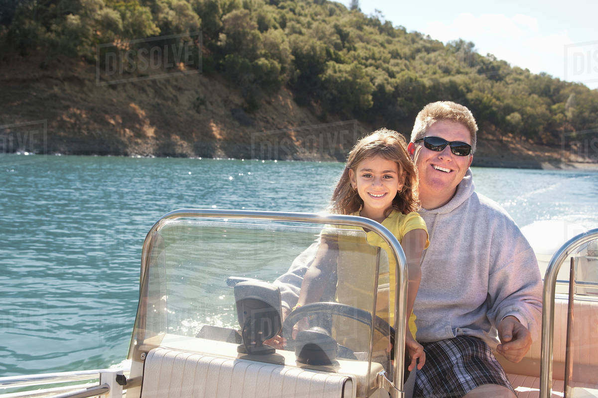 Father and daughter steering boat on lake - Royalty-free Stock Photo ...