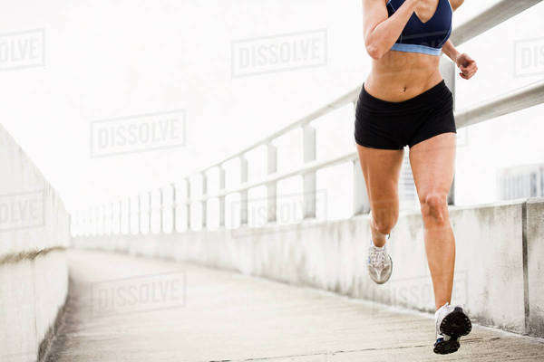 Hispanic woman running on urban walkway - Royalty-free Stock Photo ...