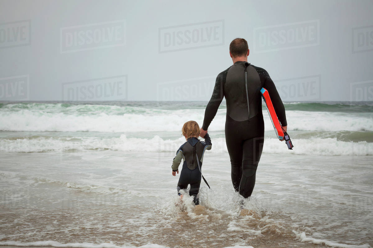 Caucasian father and son preparing to surf together - Royalty-free ...