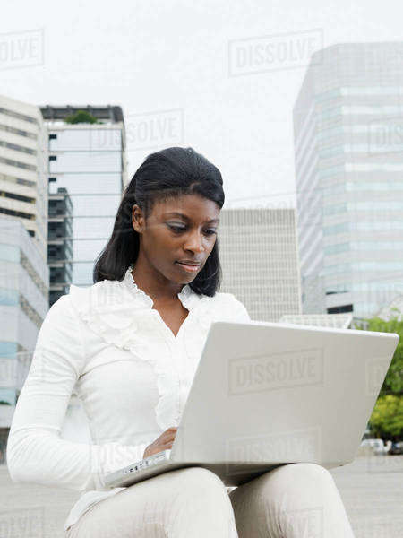 African businesswoman using laptop in city - Royalty-free Stock Photo ...