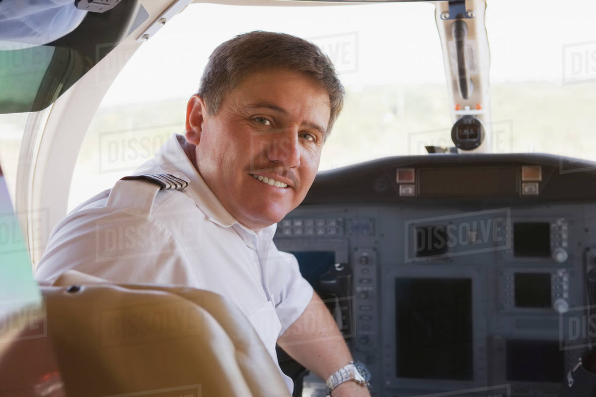 Hispanic pilot in cockpit - Stock Photo - Dissolve